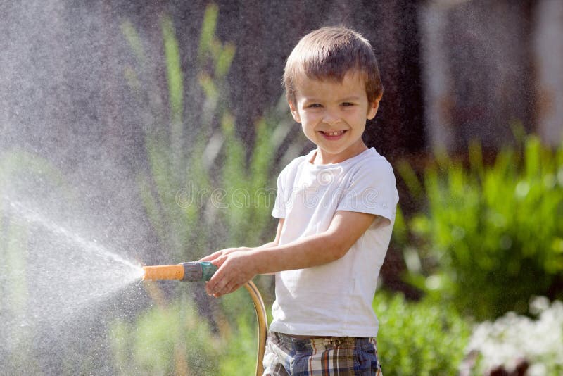 Pojke Plaskande Vatten Med En Slang Fotografering för Bildbyråer - Bild ...