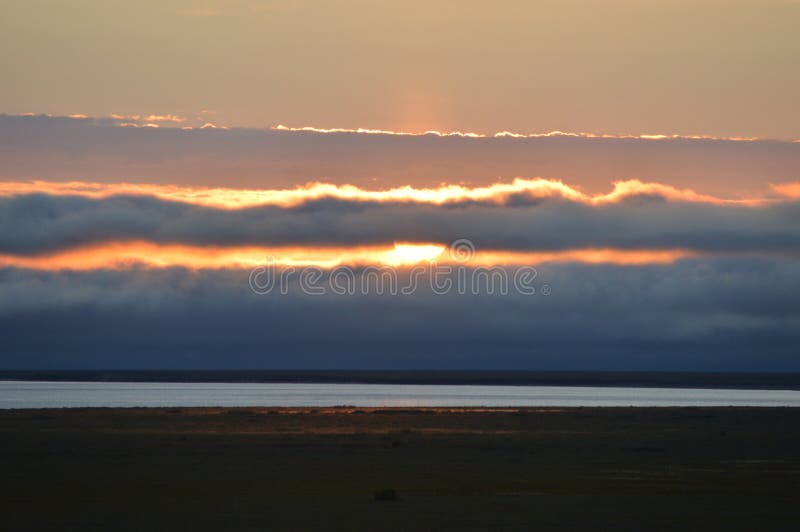 The Polar Sun Behind Puffy Clouds Stock Image - Image of dusk, sunset ...