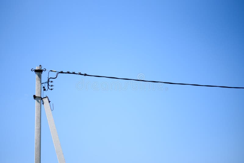 A Pole with a Power Wire on the Background of a Blue Sky Stock Photo ...