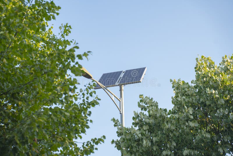 A Pole with a Street Lamp Powered by Solar Panels in the City between ...