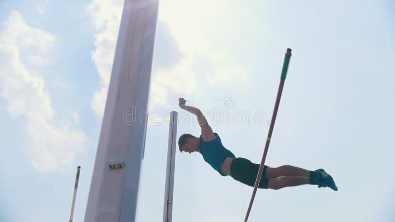 Pole Vault Training on the Stadium Outside- a Man Jumping Over the Bar ...