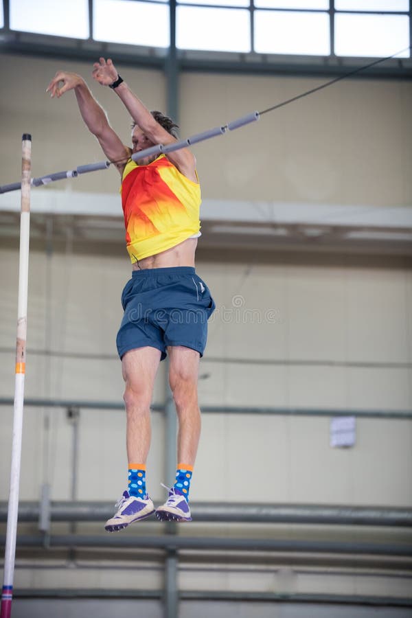 Pole Vaulting Indoors - a Man Falling Down after Jumping Over the Bar ...