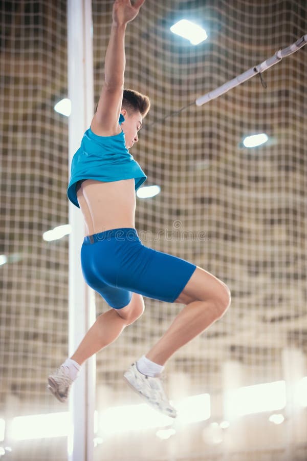 Pole Vaulting Indoors - a Sportive Man Jumping Over the Bar - Leaning ...