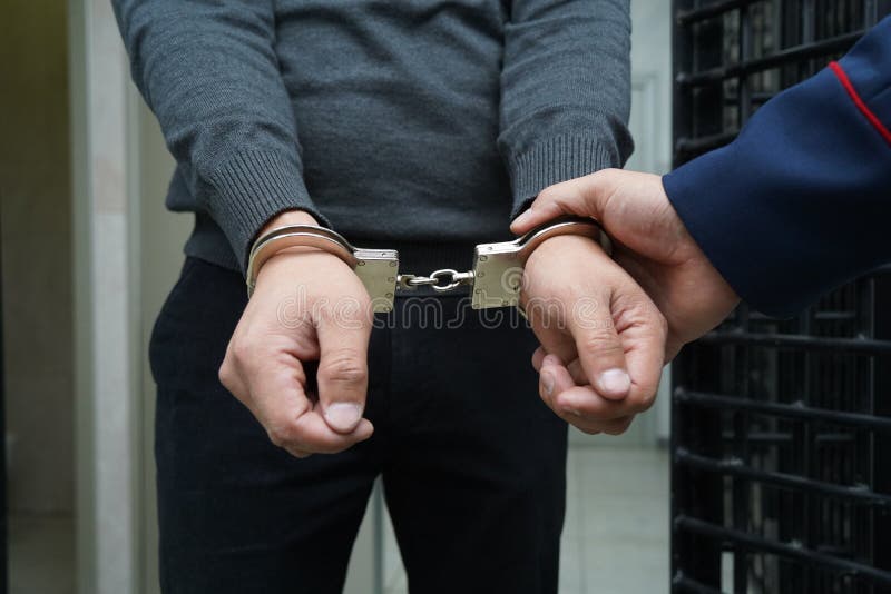 A Police Officer Handcuffs a Suspect Stock Photo - Image of face ...
