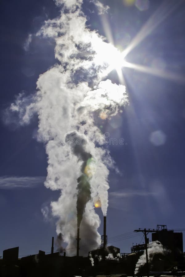 Pollution Rises into the Blue Sky in Front of a Sun Star Stock Photo ...