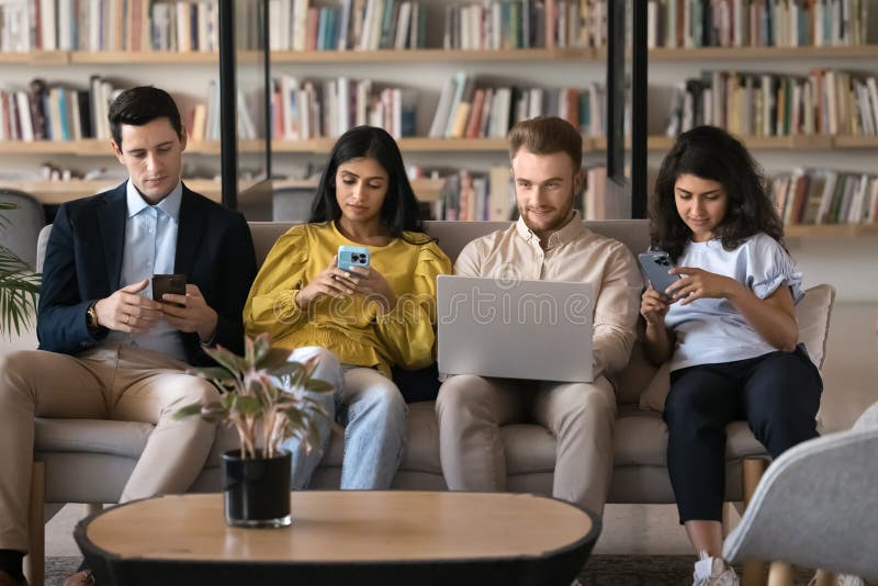 Polyethnic Students Team Use Diverse Gadgets on Sofa at Library Stock ...