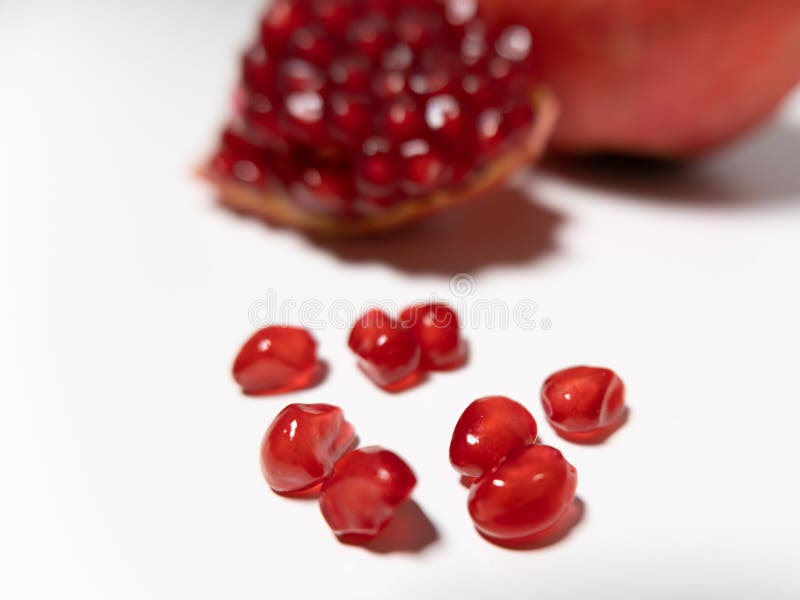 Pomegranate Fruit, Split Open with Red Seeds Spilling Onto White Table ...