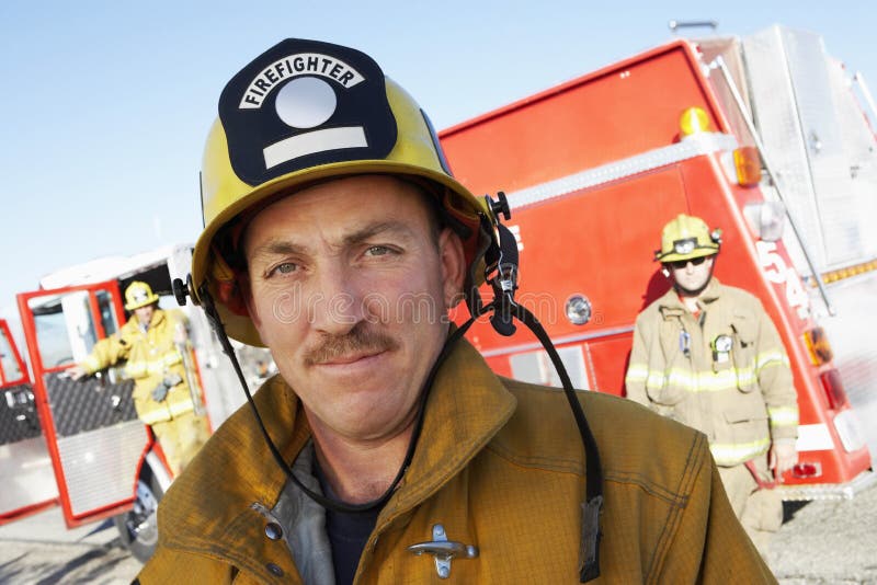 Pompier Dans Le Moteur De Front of Colleagues and Fire Photo stock ...