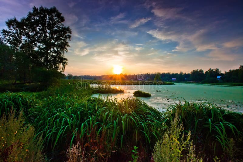 Pond at sunset stock image. Image of scenic, county, houses - 16488027