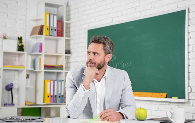 Pondering School Teacher in Classroom at Blackboard Stock Image - Image ...