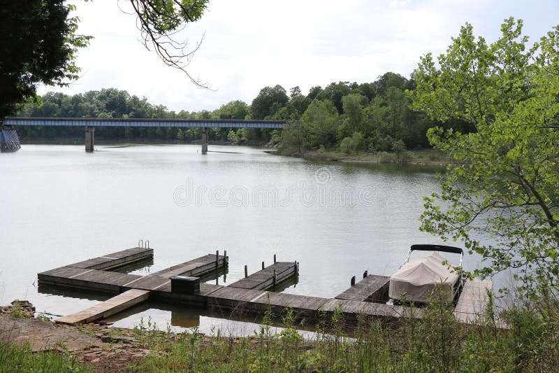 Pontoon Boat Parked at a Dock on a Lake with a Bridge in the Back Stock ...