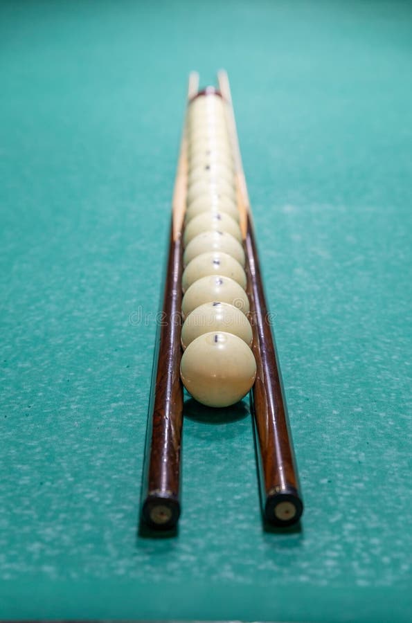 Pool Billiard Balls in a Row Next To a Cue on a Blue Table. Focus on ...