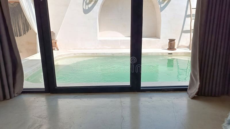 A Pool is Visible through a Window in a Building Stock Image - Image of ...