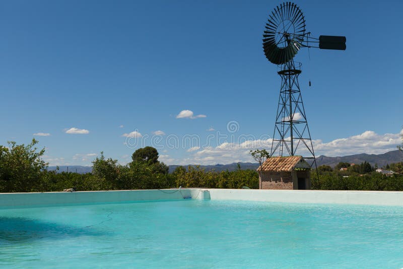 A Traditional Old Windmill Next To a Pool of Water. Stock Photo - Image ...
