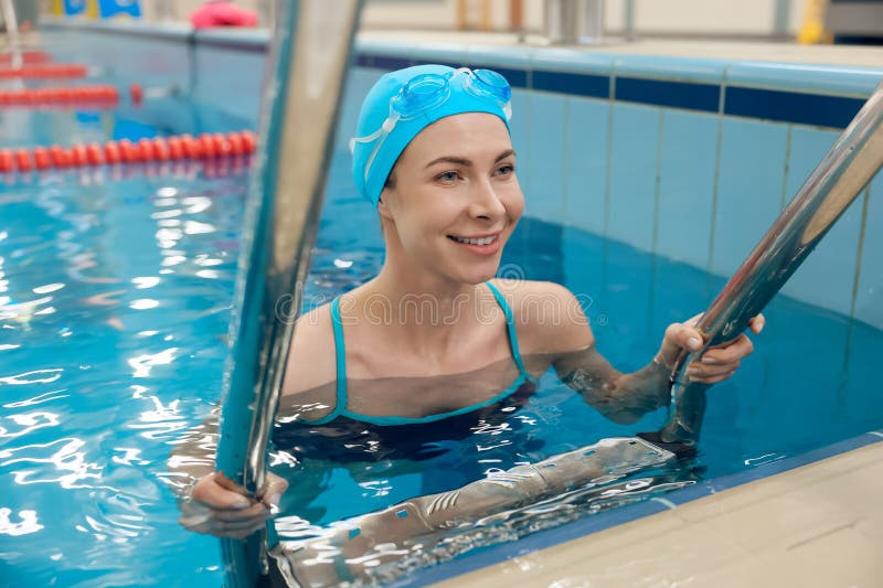 Woman in Blue Swimming Cap on the Ladder in the Pool Stock Photo ...