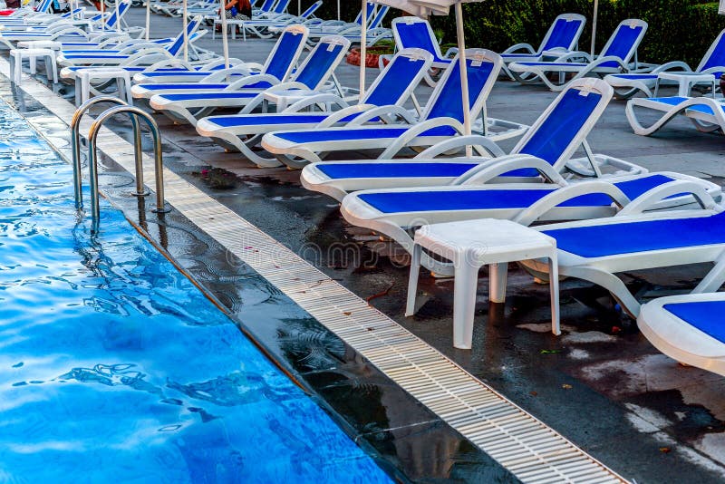 Poolside with Blue Chezlongs and Pool Close Up View Stock Image - Image ...