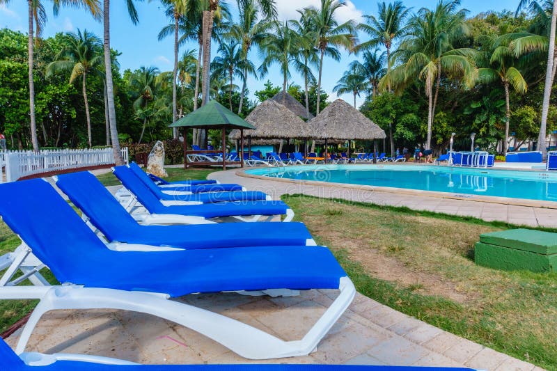A Poolside with a Row of Lounge Chairs and a Few Umbrellas Stock Image ...