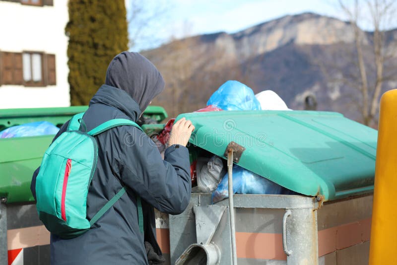 Poor Boy with a Backpack on His Back Searching in the Rubbish Bi Stock ...