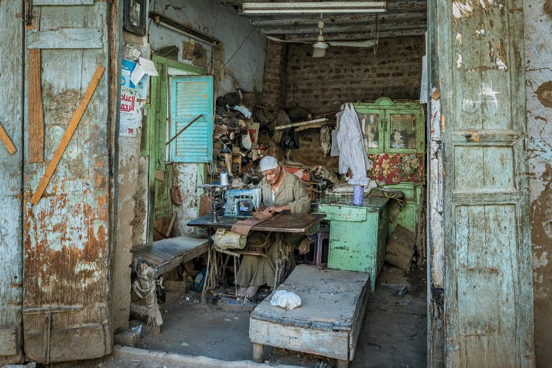A Poor Egyptian Tailor Using His Old Sewing Machine in a Simple Hovel ...