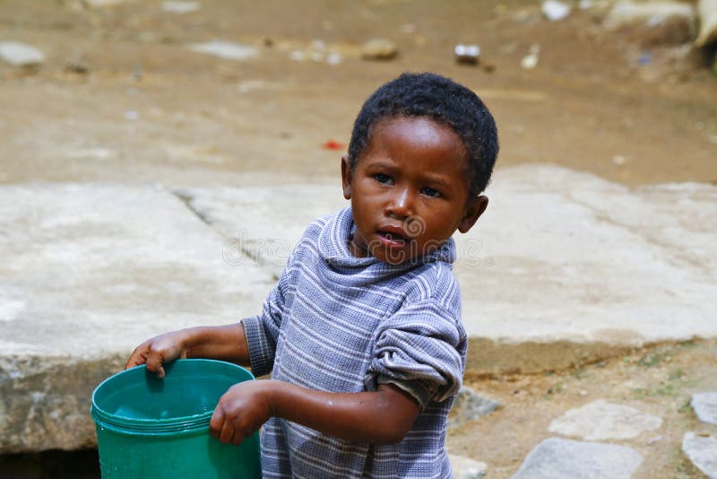 Poor Malagasy Boy Carrying Plastic Water Bucket Stock Photo - Image of ...