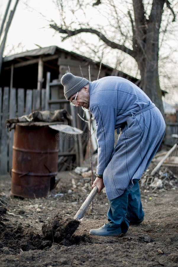 Poor and Old Romanian Man Working His Land in a Traditional Way with ...