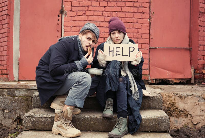 Poor Young Couple with HELP Sign and Bread on Street Stock Image ...