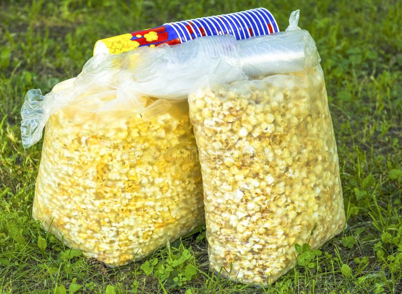 Popcorn in Transparent Big Packages on a Grass. Stock Image - Image of ...