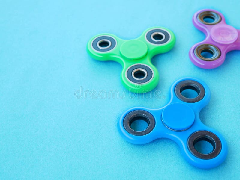 Popular Colourful Fidget Spinner Toy on a Colored Background Stock ...