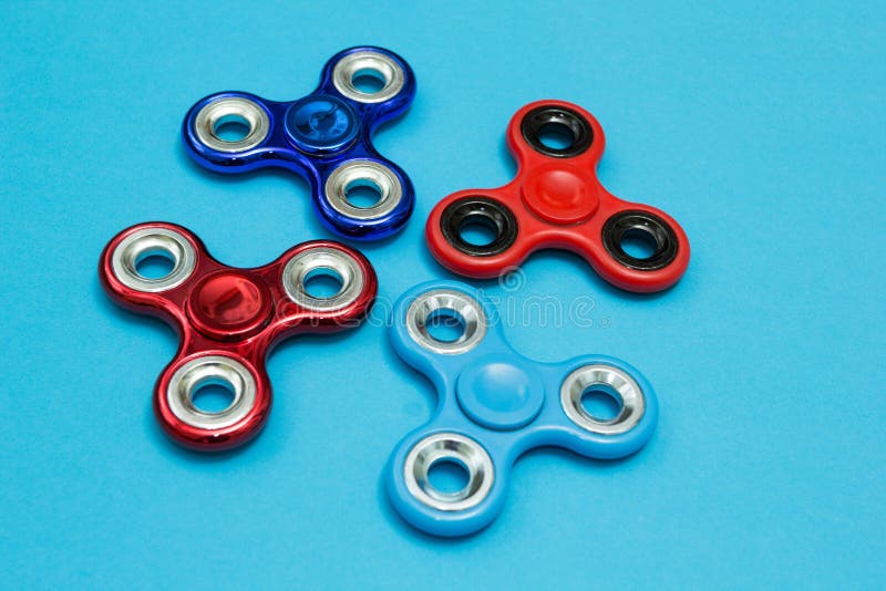 Popular Fidget Spinner Toy. Blue Background Stock Photo - Image of ...