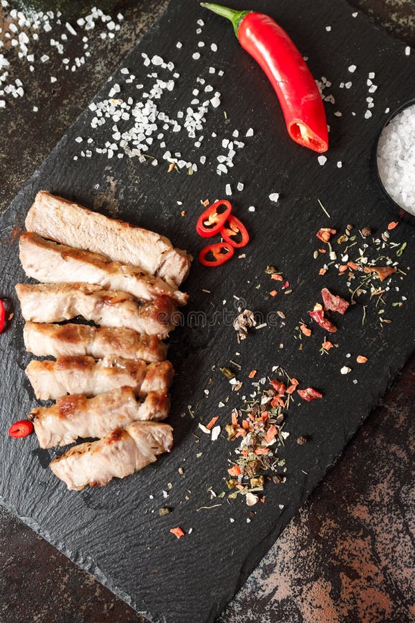 Pork Cooked in a Pan and Cut into Pieces with Spices on a Dark Stone ...