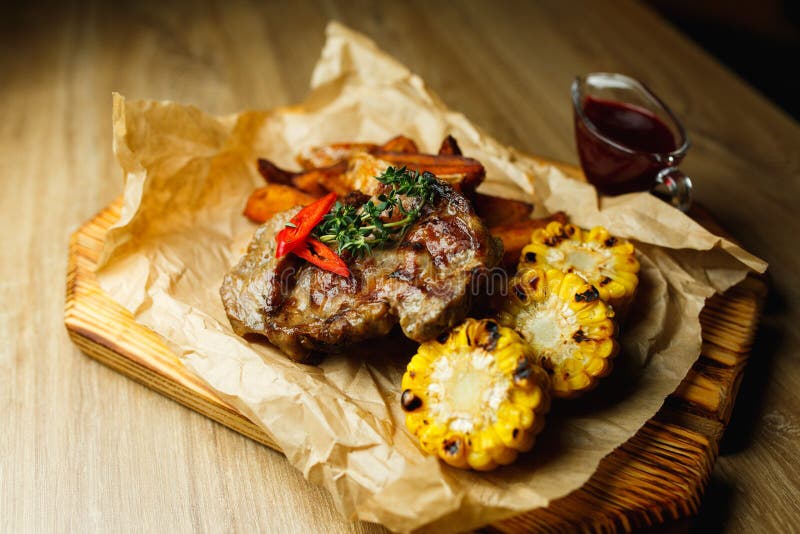Pork Steak with Grilled Corn and Potatoes in Creole Stock Photo - Image ...