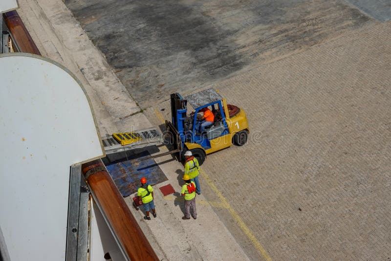 Port Dock Workers Using a Forklift To Setup a Ramp To Transport ...