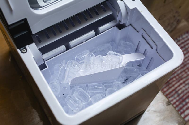 A Portable Automatic Ice Maker with the Lid Open, Showing an Ice Cube ...