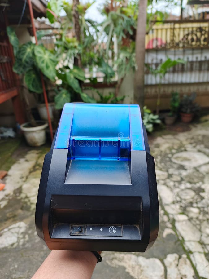 Portable Bluetooth Printer on Hand, Blue Color with Blur Background ...