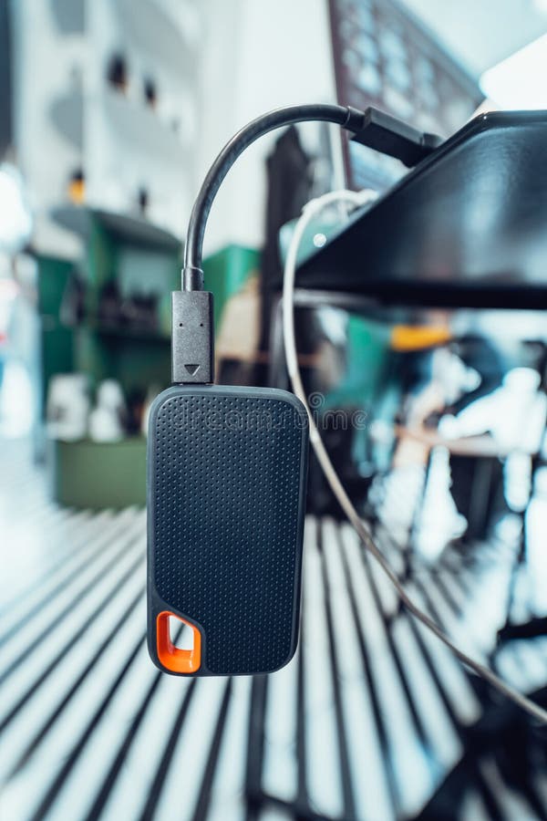 A Portable Hard Drive Connected To a Laptop Hangs Down on a USB Cable ...