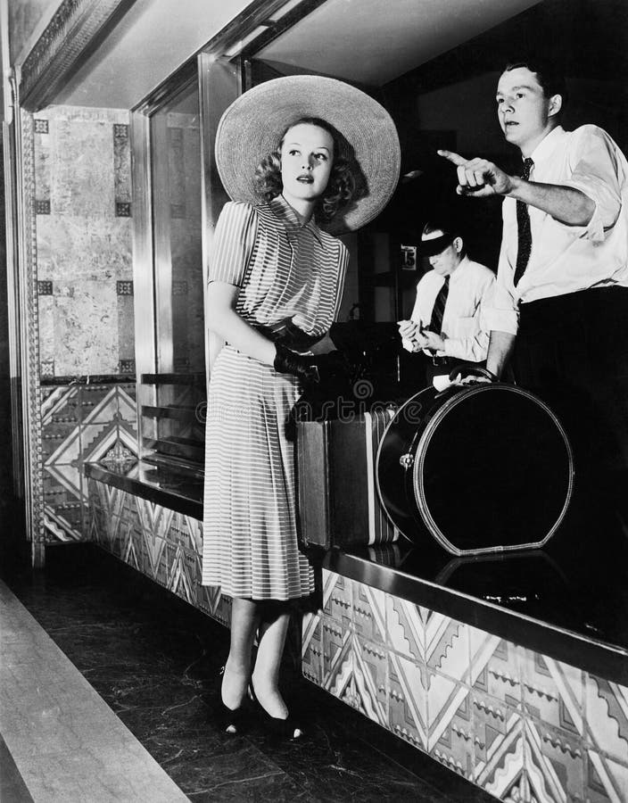 Porter Pointing Something Out To an Elegant Woman Stock Image - Image ...