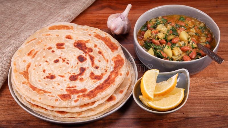 Portion of African Chapati, Bean Stew, Garlic, and Lemons Stock Image ...