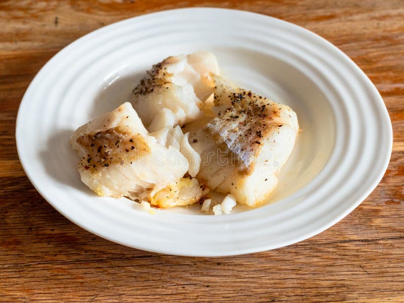 Portion of Baked Cod Fish on White Plate on Table Stock Photo - Image ...