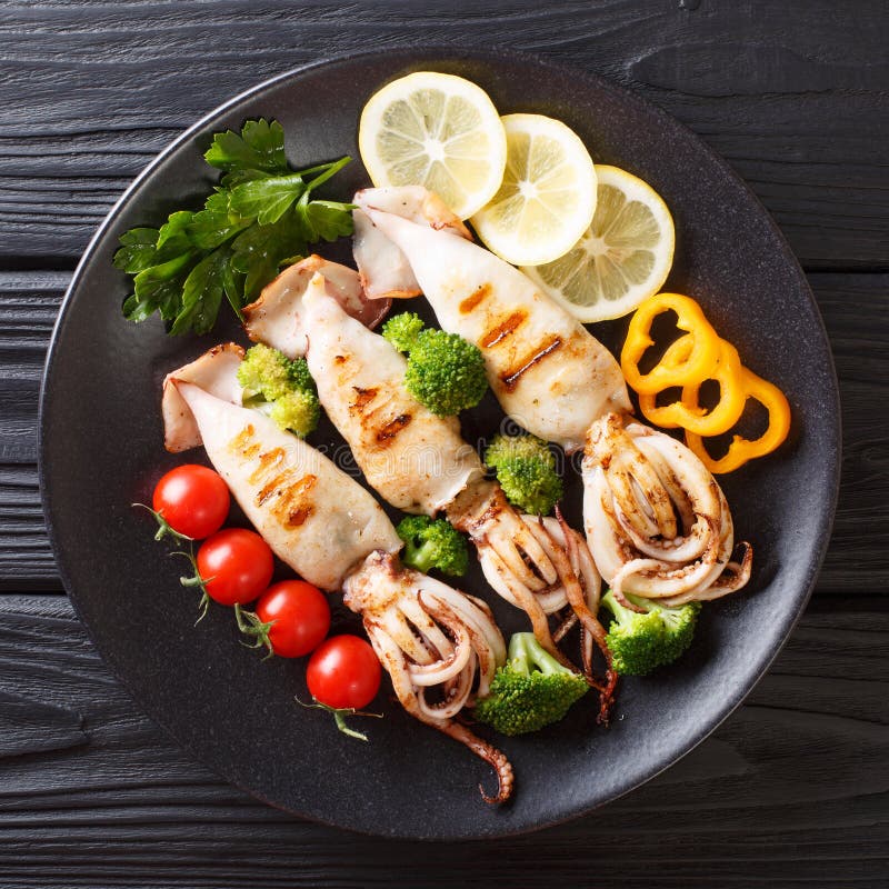 Portion of Grilled Squid with Fresh Vegetables Close-up on a Plate on a ...