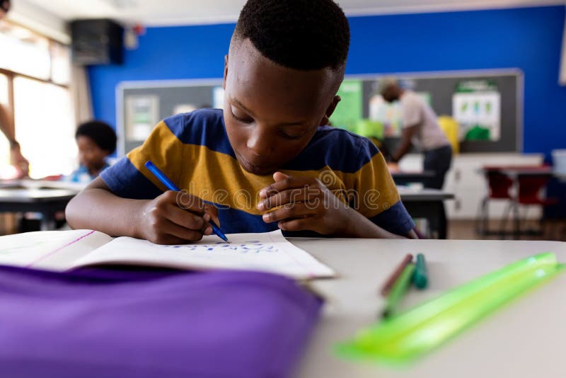 Portrait of African American Boy Writing in Classroom at Elementary ...