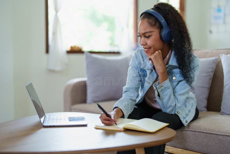 African American Using a Notebook and Computer To Study Online at Home ...
