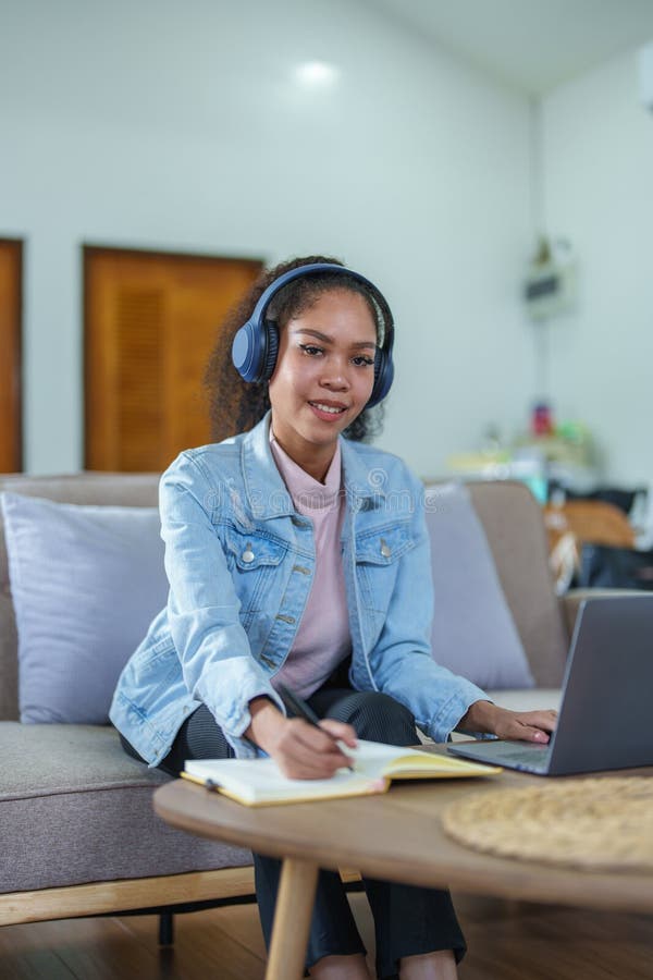African American Using a Notebook and Computer To Study Online at Home ...