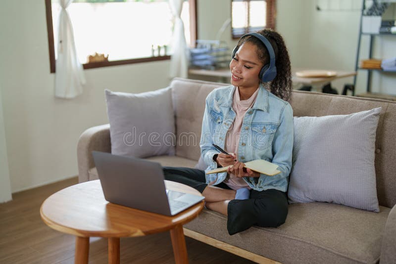African American Using a Notebook and Computer To Study Online at Home ...