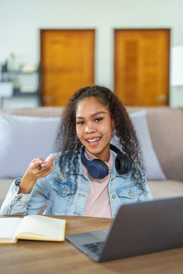African American Using a Notebook and Computer To Study Online at Home ...