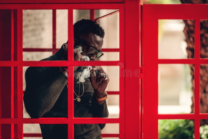 Portrait of African Model Using Smartphone while Smoking Cigar in ...