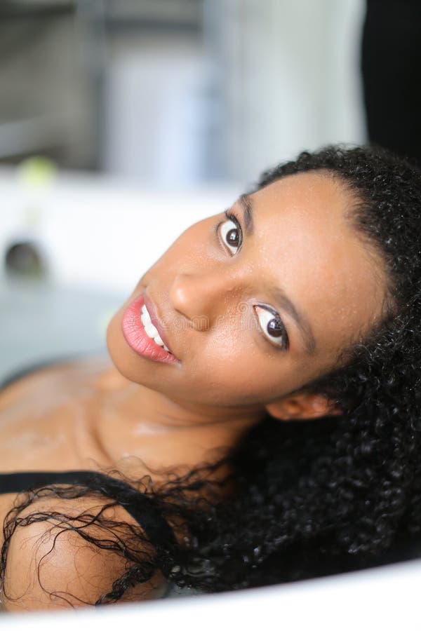 Portrait Of Curly Haired Black Girl Sitting In Bathroom And Wearing