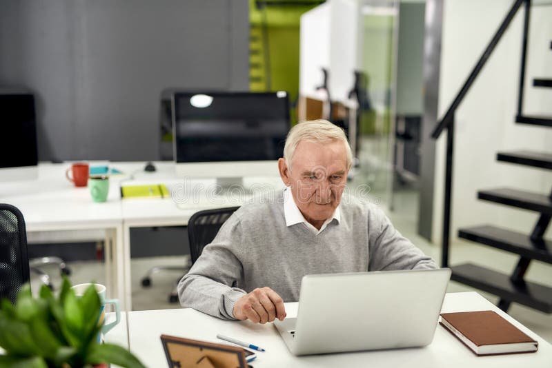 Portrait Of Aged Man Senior Intern Looking Focused At The Screen While