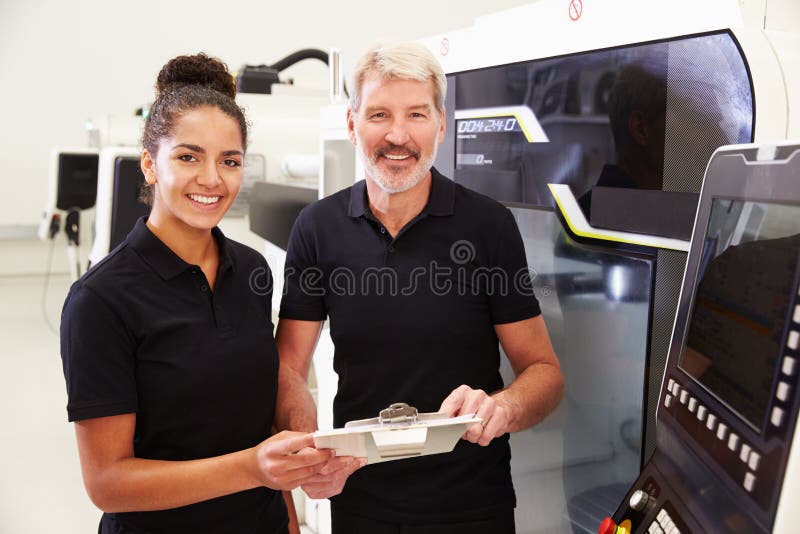 Portrait of Apprentice Working with Engineer on CNC Machine Stock Photo ...