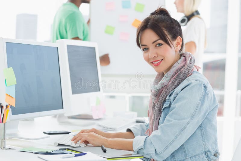 Portrait of an Artist Using Computer with Colleagues Behind Stock Image ...