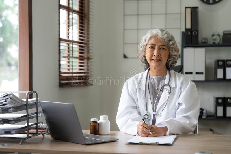 Portrait of Asian Doctor Working at Her Table in Clinic Stock Photo ...